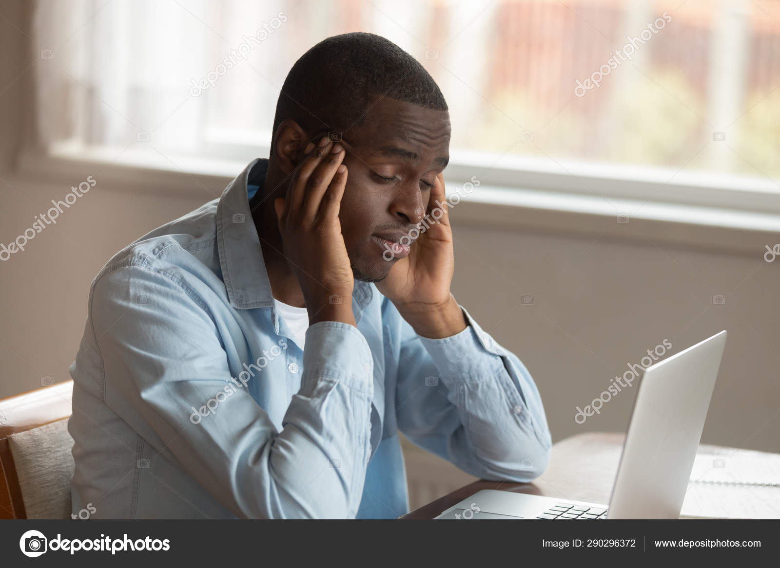 African guy sitting near computer rubbing temples feels unwell — Stock ...