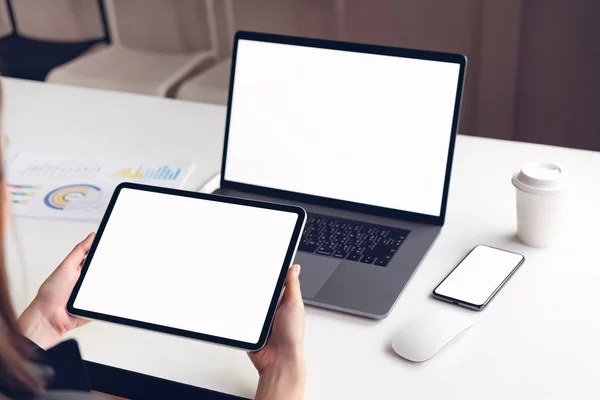 Woman holding tablet screen blank and laptop on the table mock up to ...