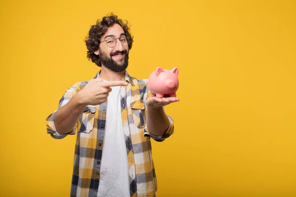 young crazy mad man in fool pose with a piggy bank. Savings concept ...
