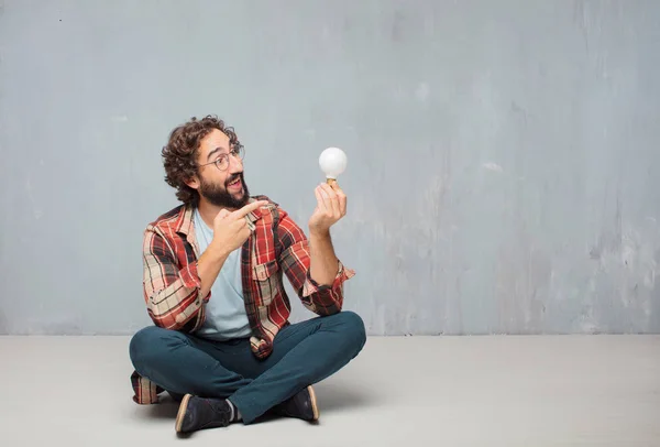 young crazy mad man in fool pose with a light bulb. Idea or inspiration ...