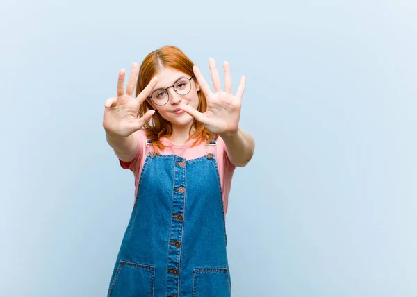 young red head pretty woman smiling and looking friendly, showing ...