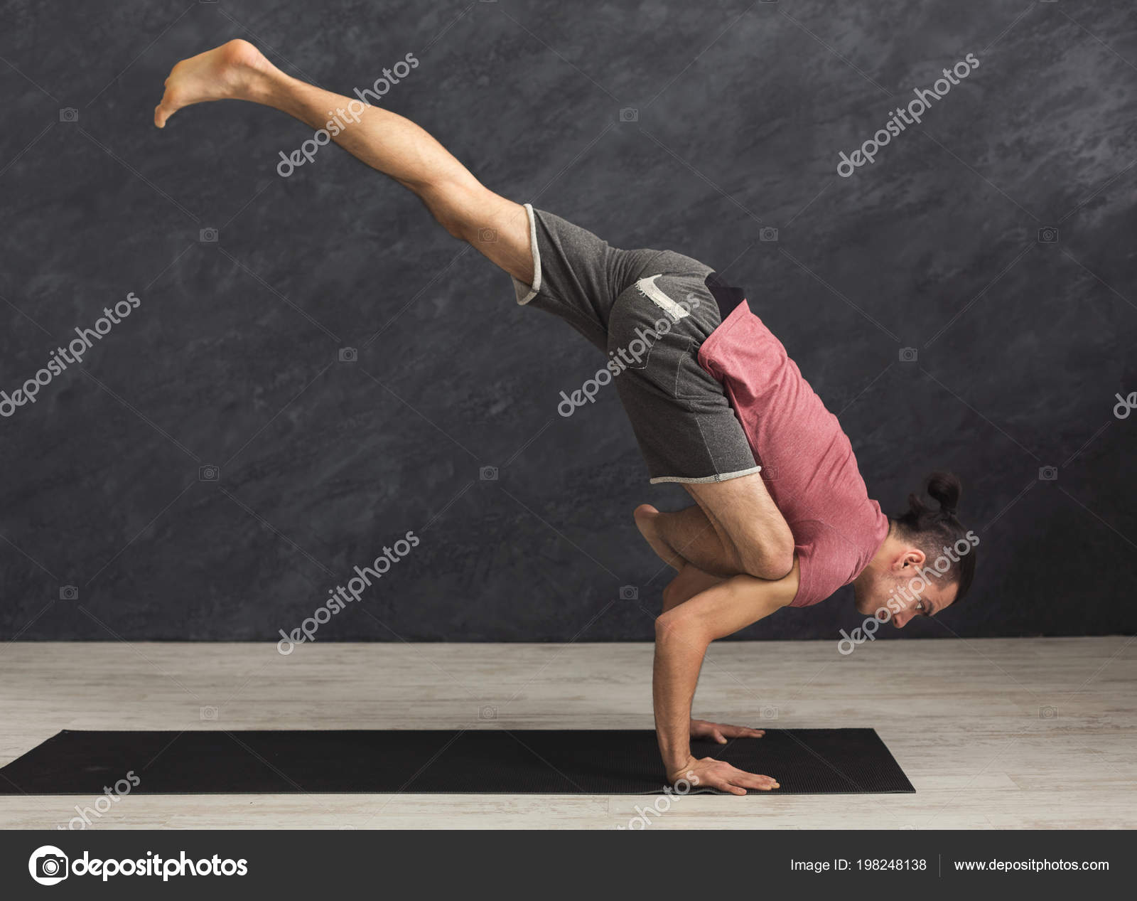 Young flexible man standing on hands — Stock Photo © Milkos #198248138