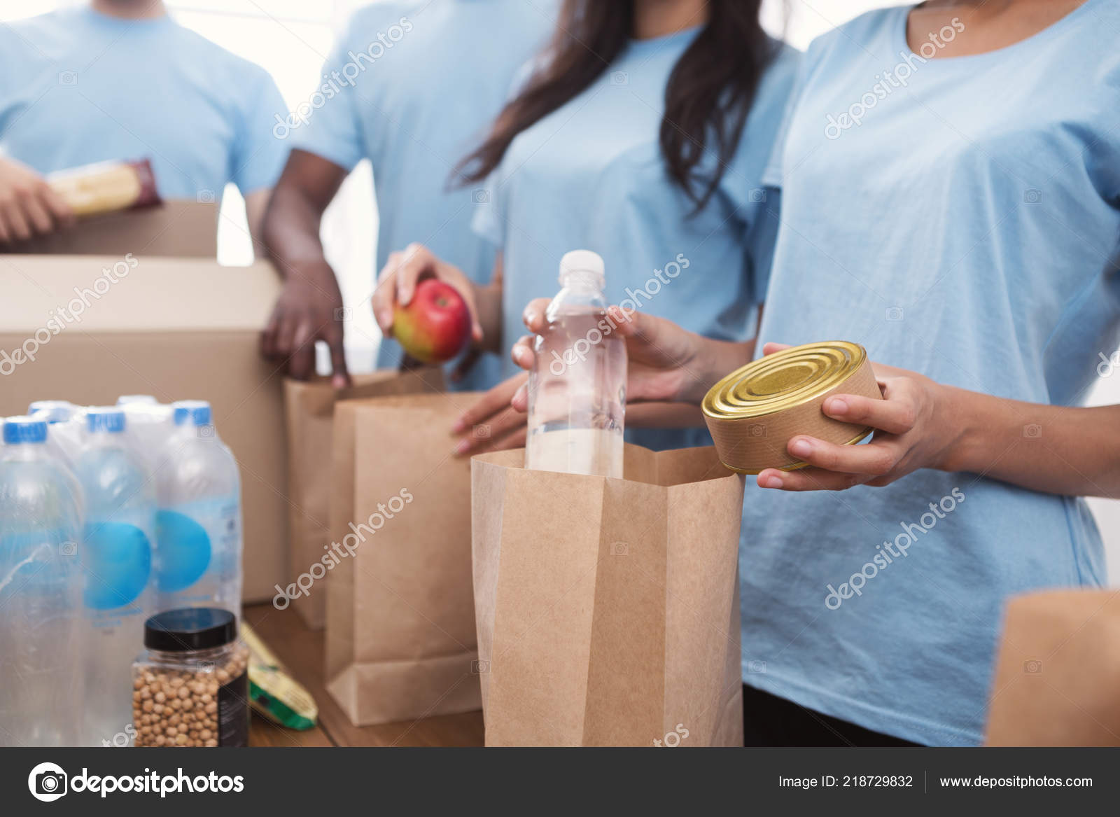 Volunteers packing food and drinks into paper bags Stock Photo by ...