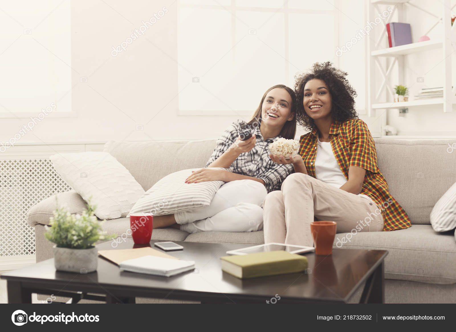 Smiling female friends watching TV at home — Stock Photo © Milkos ...