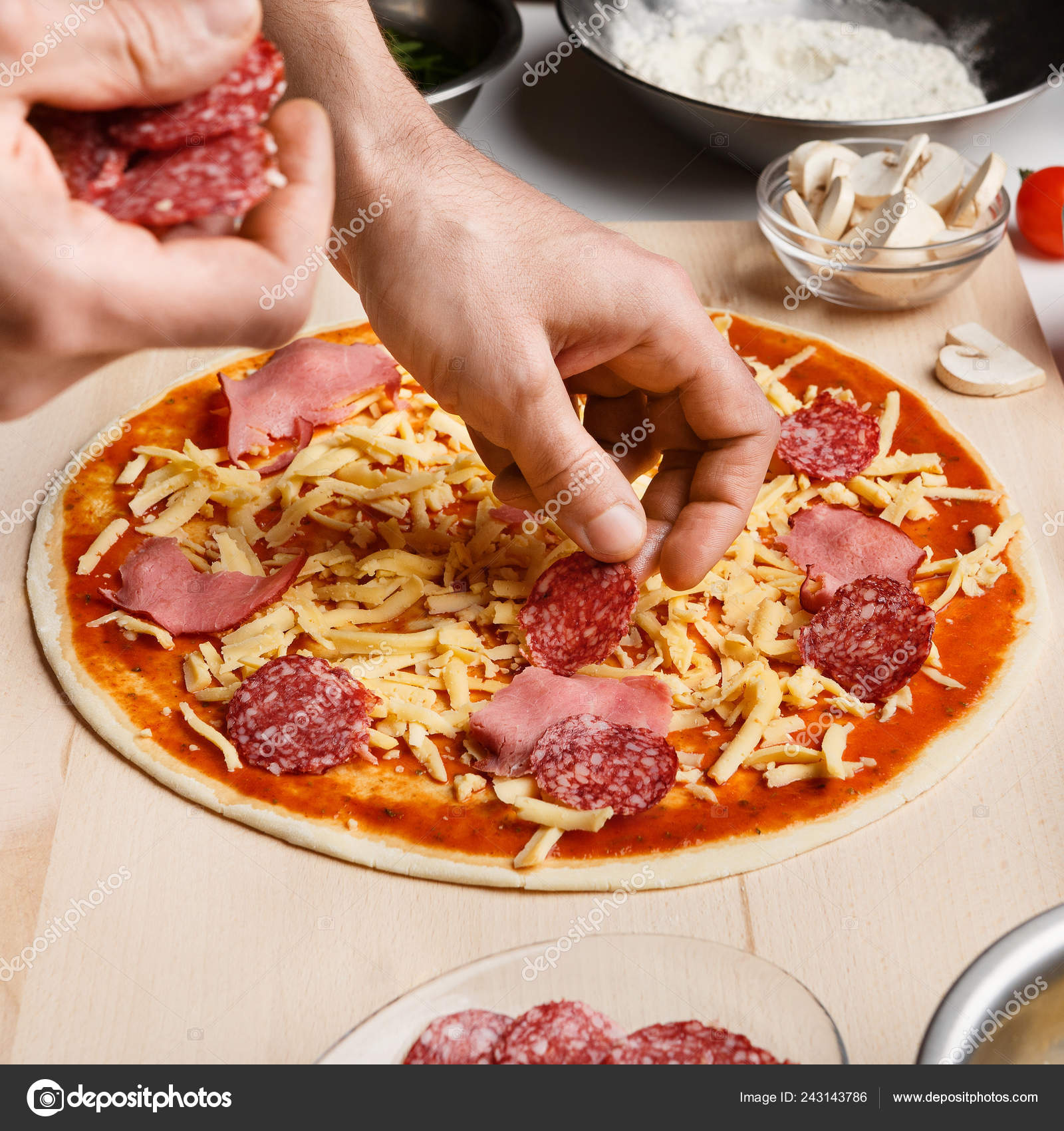 Chef putting salami over cheese on raw pizza Stock Photo by ©Milkos ...