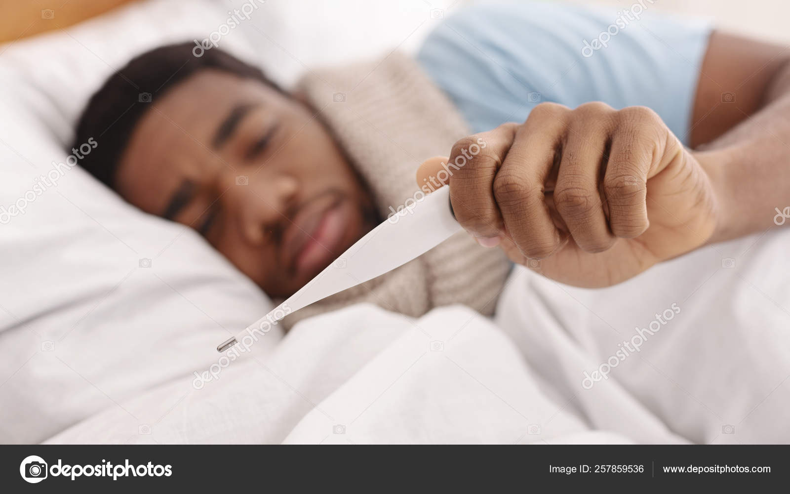 Sick guy with fever checking his temperature in bed — Stock Photo ...