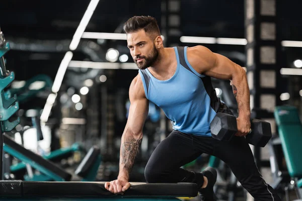 Millennial muscular man doing exercises with dumbbells - Stock Image ...