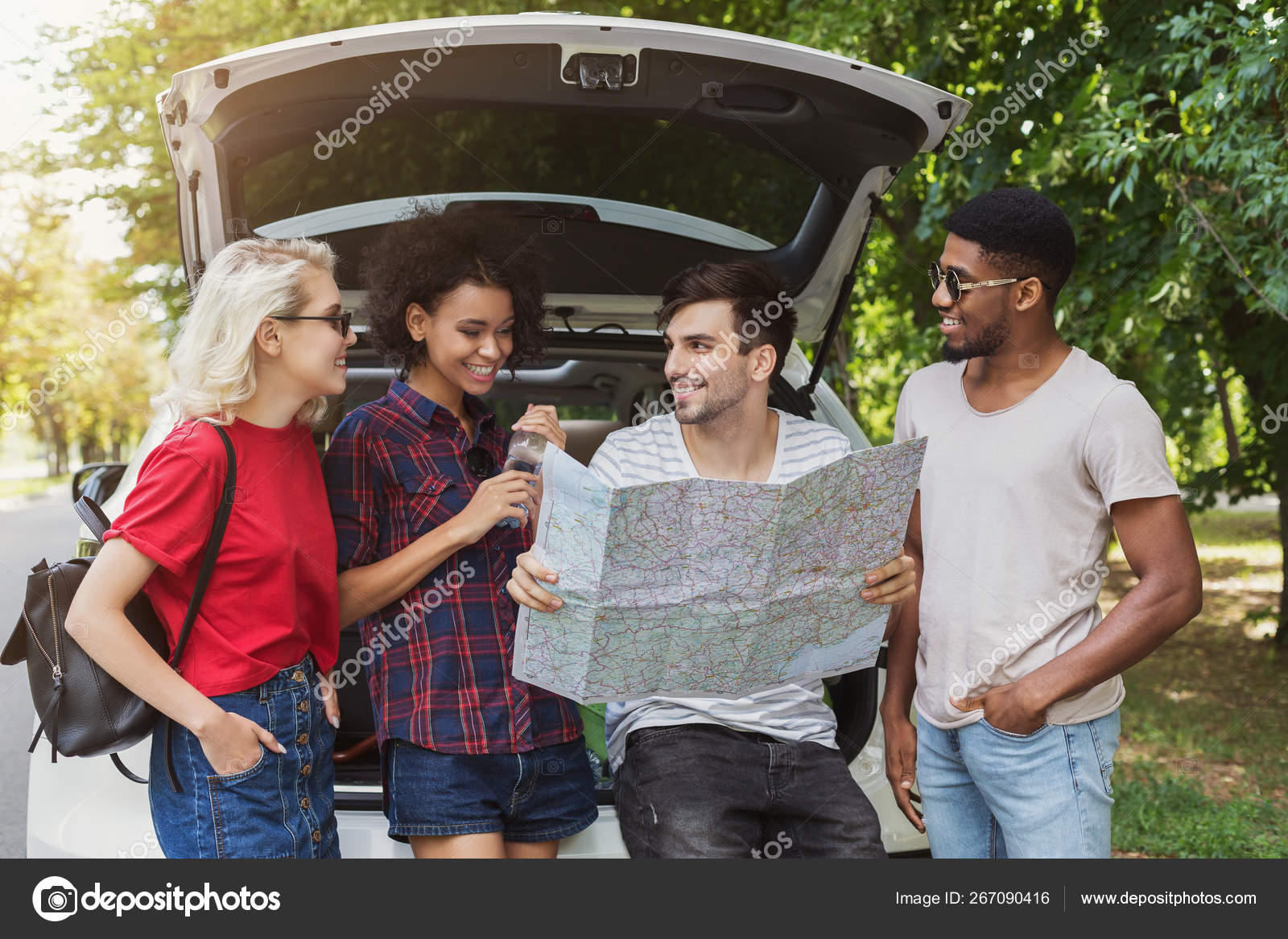 Friends at open car back with map — Stock Photo © Milkos #267090416