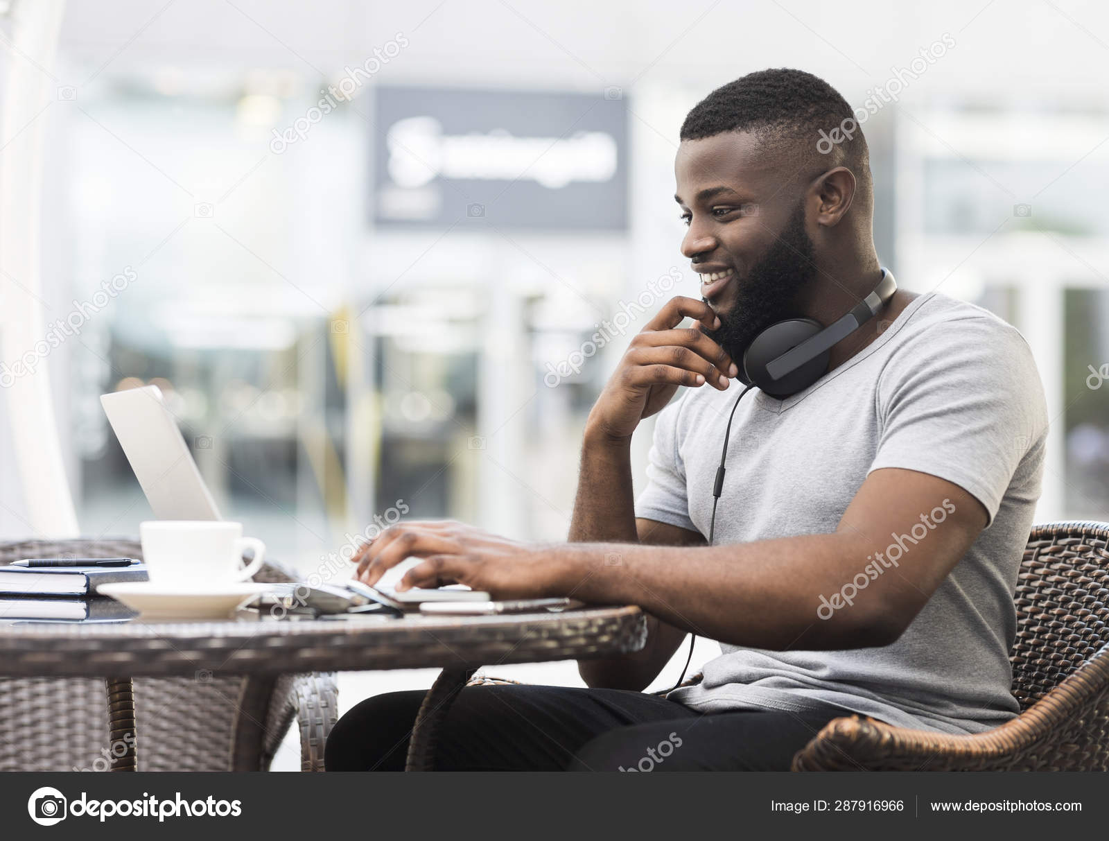 Handsome african guy using his laptop with free wifi in cafe — Stock ...