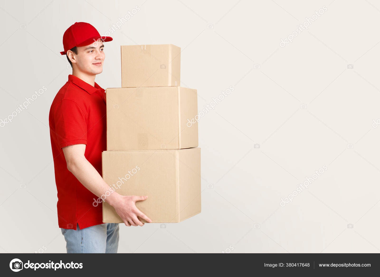 Postman issues parcels. Worker holds stack of parcels in his hands ...