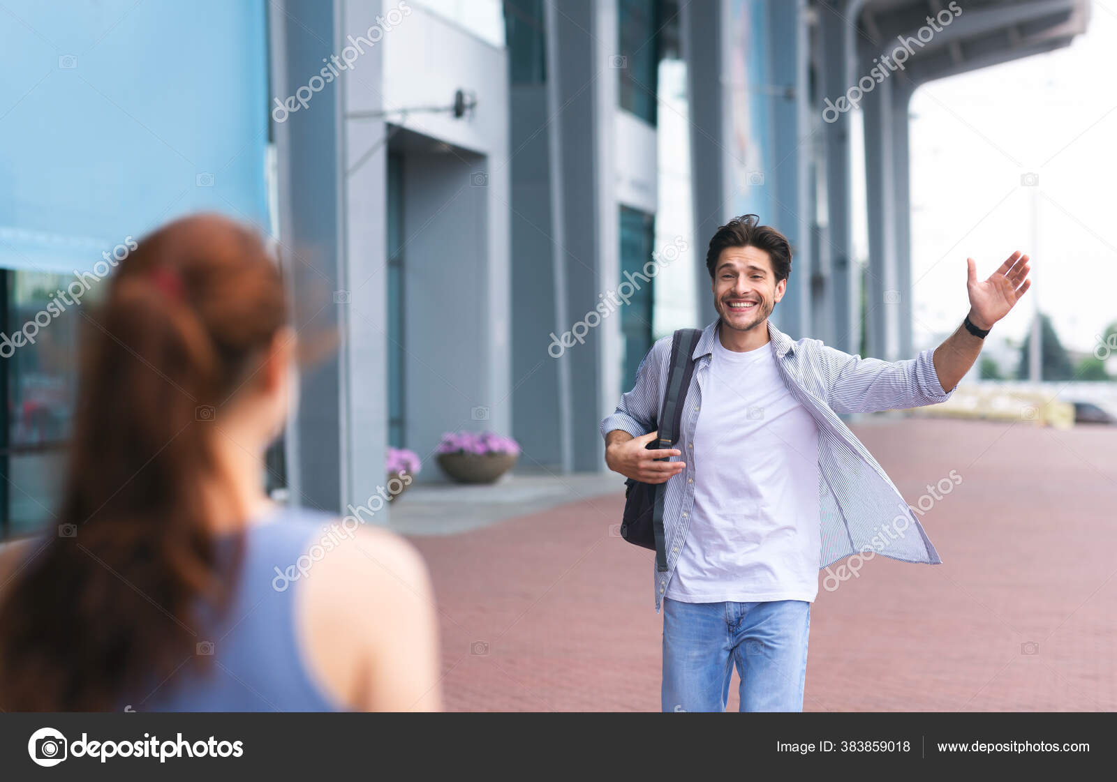 Long-awaited arrival. Happy guy waving hand, greeting girlfriend near ...