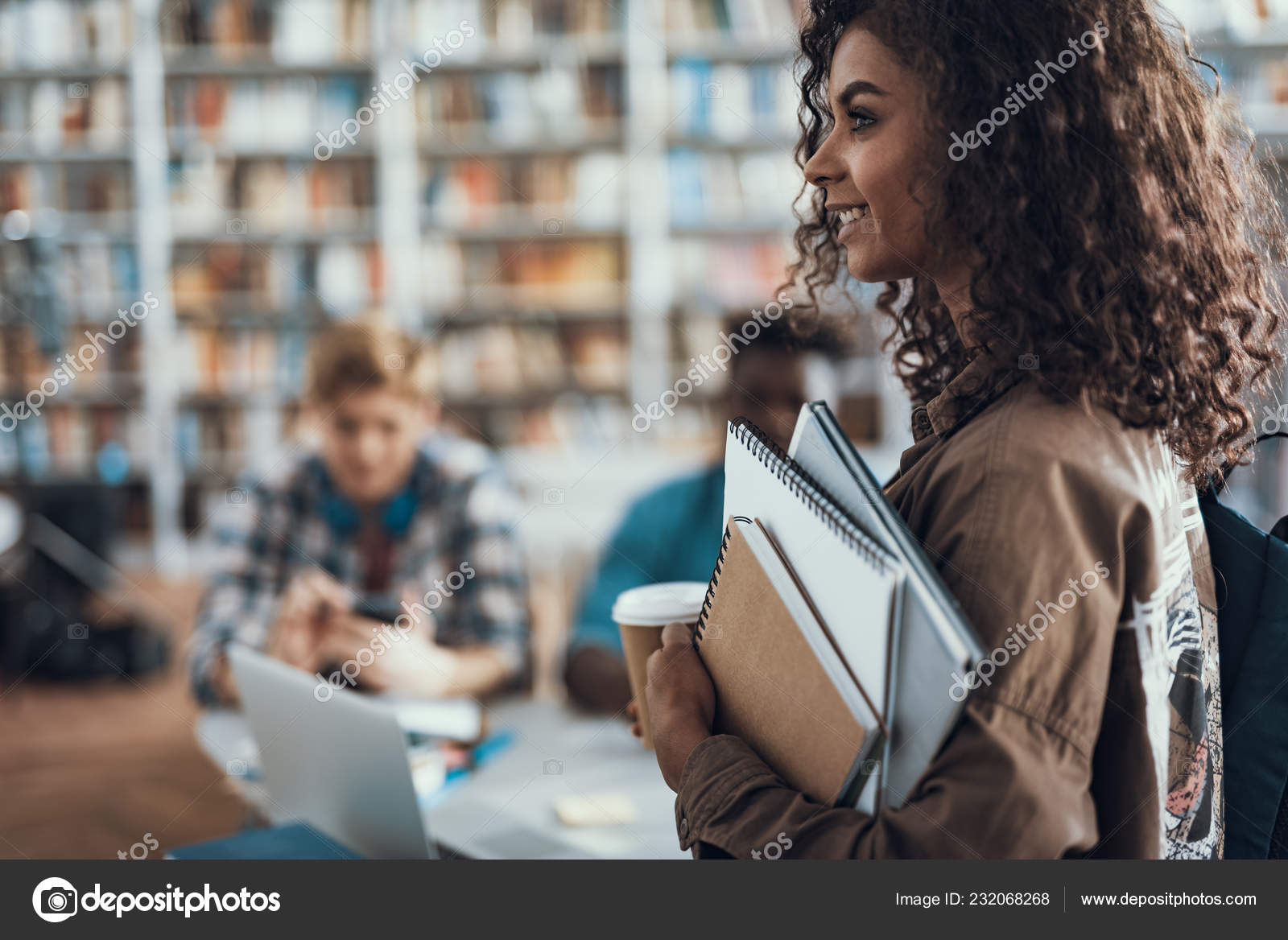 Cheerful student carrying notebooks and looking into the distance ...