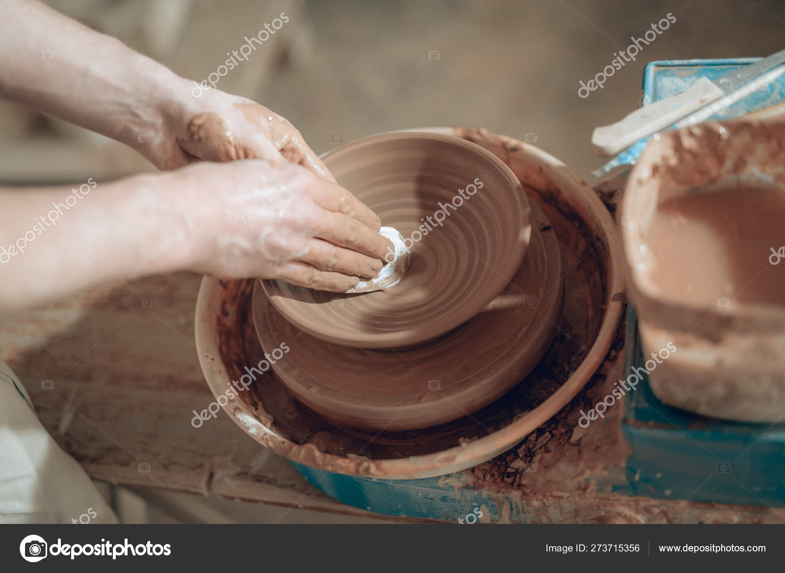 High angle of clay masters dirty arms working on potters wheel Stock ...