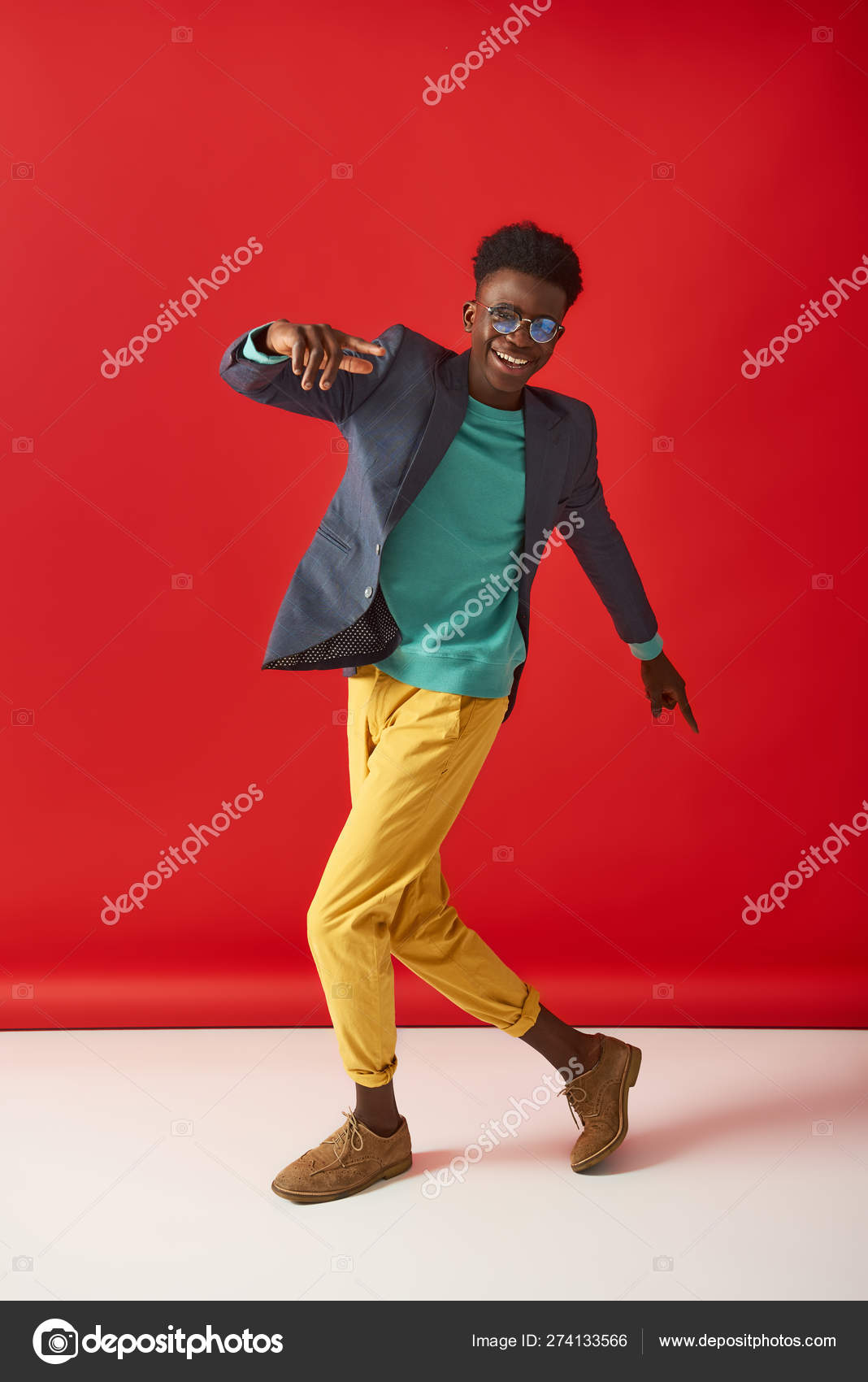 Positive young guy is dancing on red background Stock Photo by ...