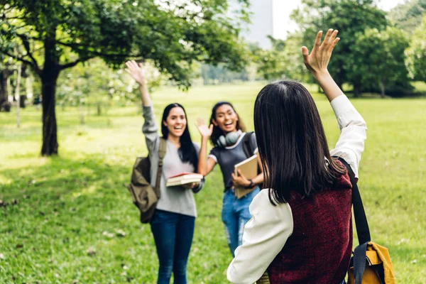 Woman student waving hello with her friend - friendship and toge ...