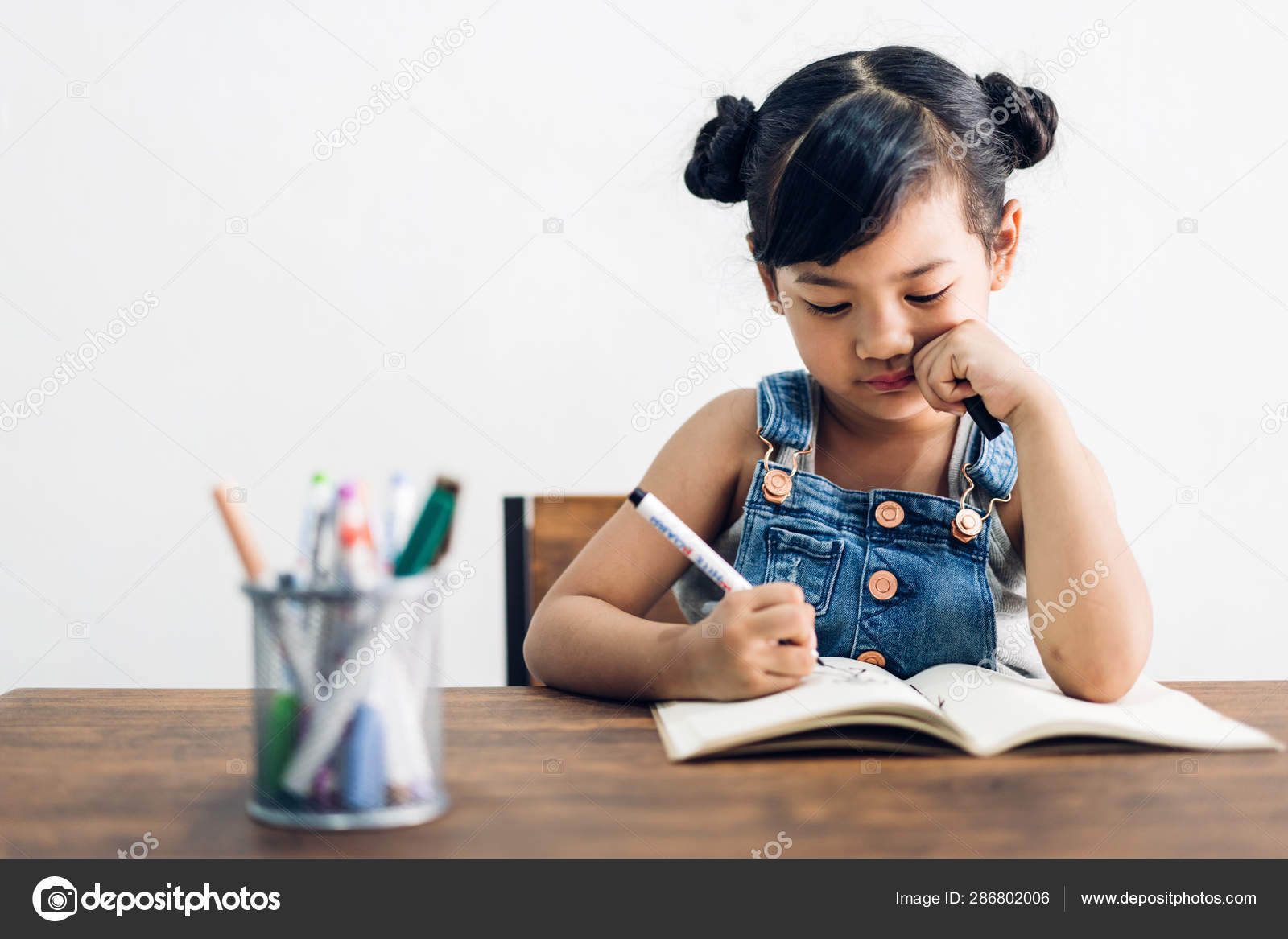 School kid little girl learning and writing in notebook with pen Stock ...