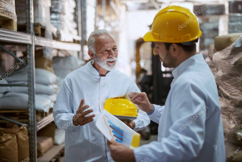 Dos supervisores que trabajan duro analizando la venta mientras est n en el almac n. M s joven ...