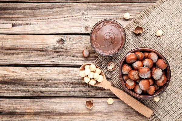 Melted chocolate with hazelnuts on brown wooden table - Stock Image ...