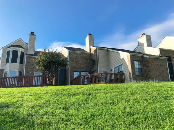 Low angle view green grassy lawn backyard of townhouse complex in ...