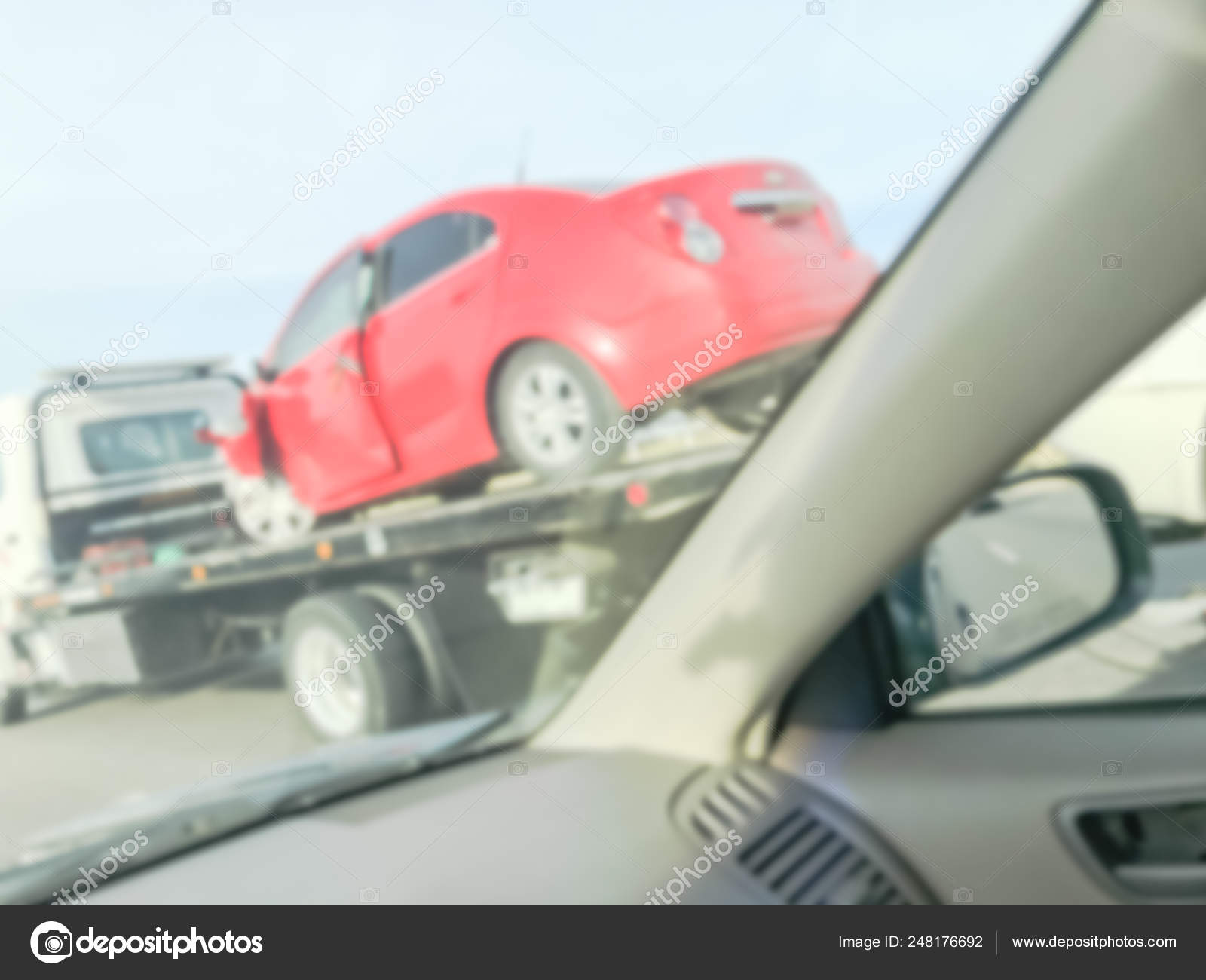 Blurry background rear view of smashed car on tow truck after crash ...