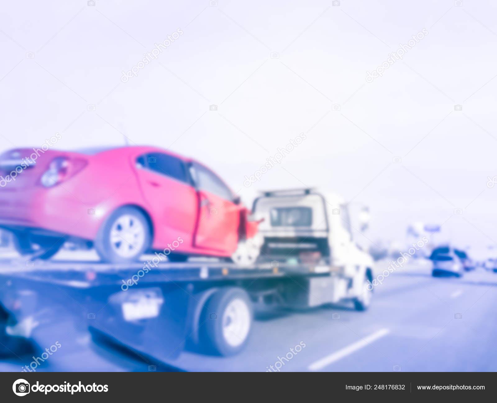 Blurry background rear view of smashed car on tow truck after crash ...
