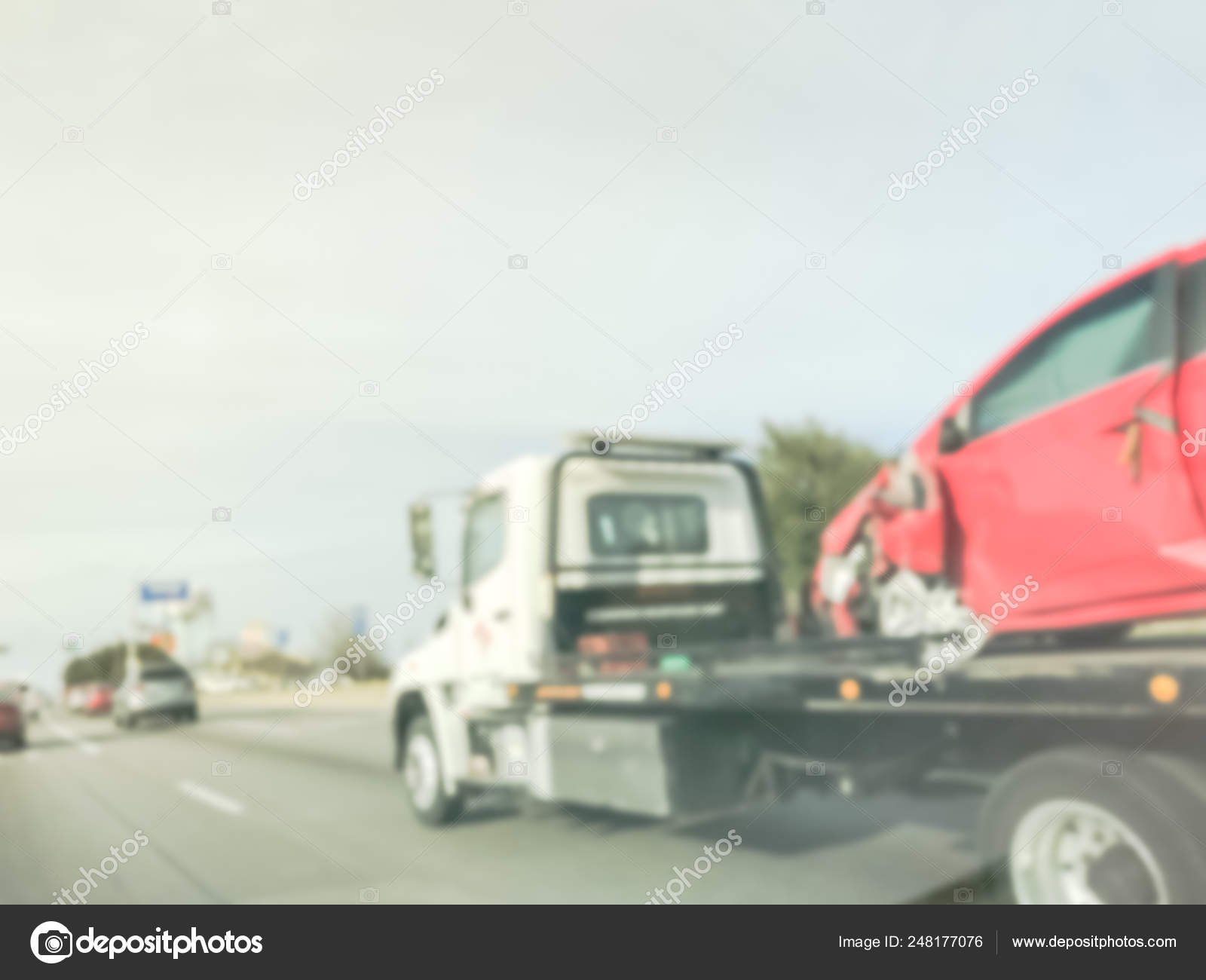 Blurry background rear view of smashed car on tow truck after crash ...
