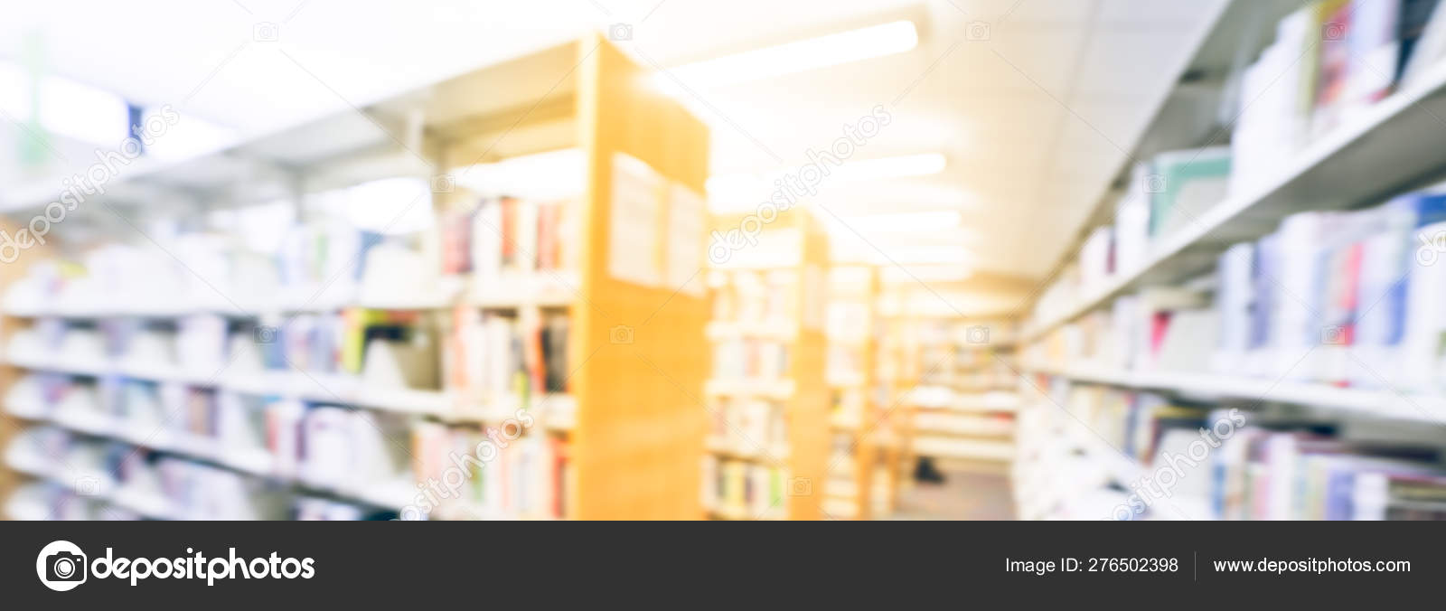 Panoramic view blurry background aisle of bookshelf with step stool at ...
