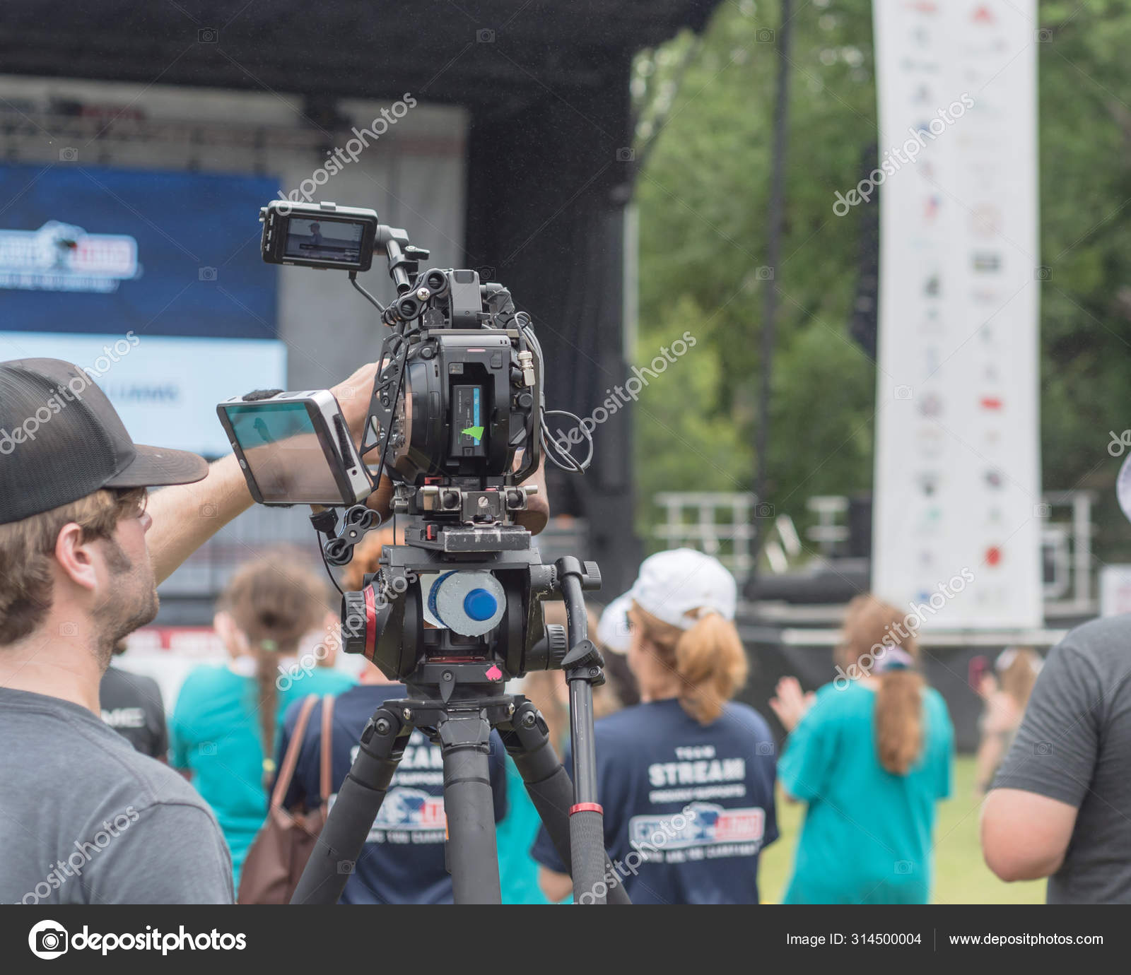 Video operator wear cap operating video recorder at live event in ...