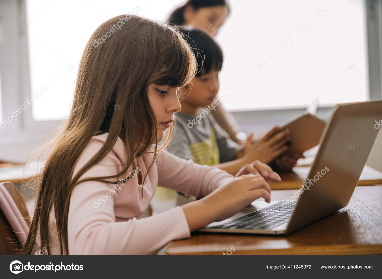 School children using computer laptop in school classroom, digital ...