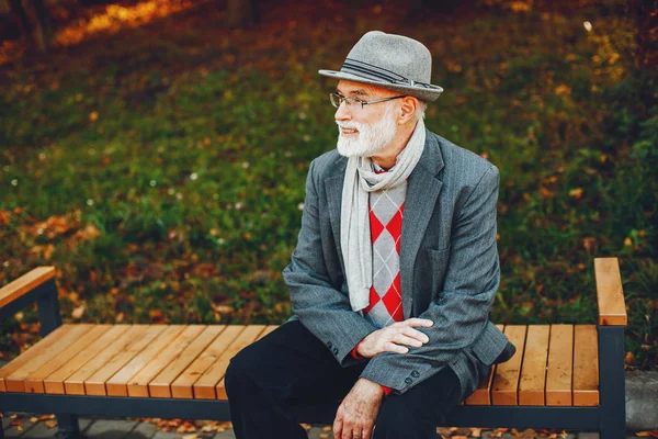 Elegant old man in a sunny autumn park - Stock Image - Everypixel