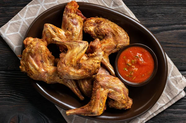 Grilled rabbit legs with spicy tomato dip. - Stock Image - Everypixel