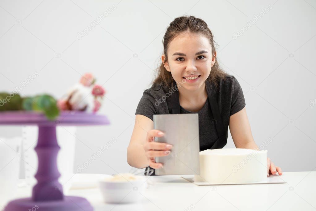 Blanco pastel cilíndrico liso en blanco. El pastelero crea la forma de ...