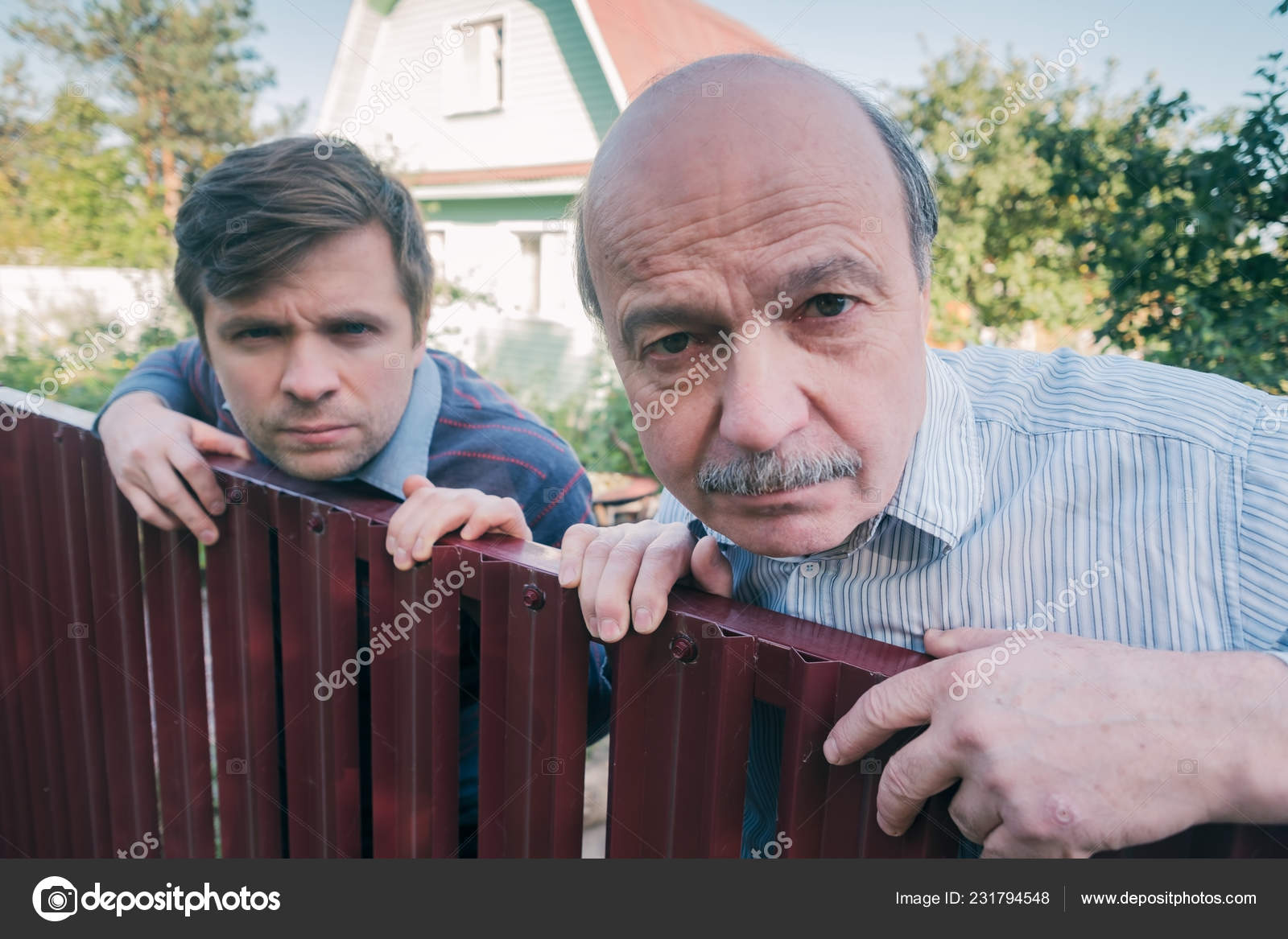 Two caucasian men carefully watching over the fence. Stock Photo by ...