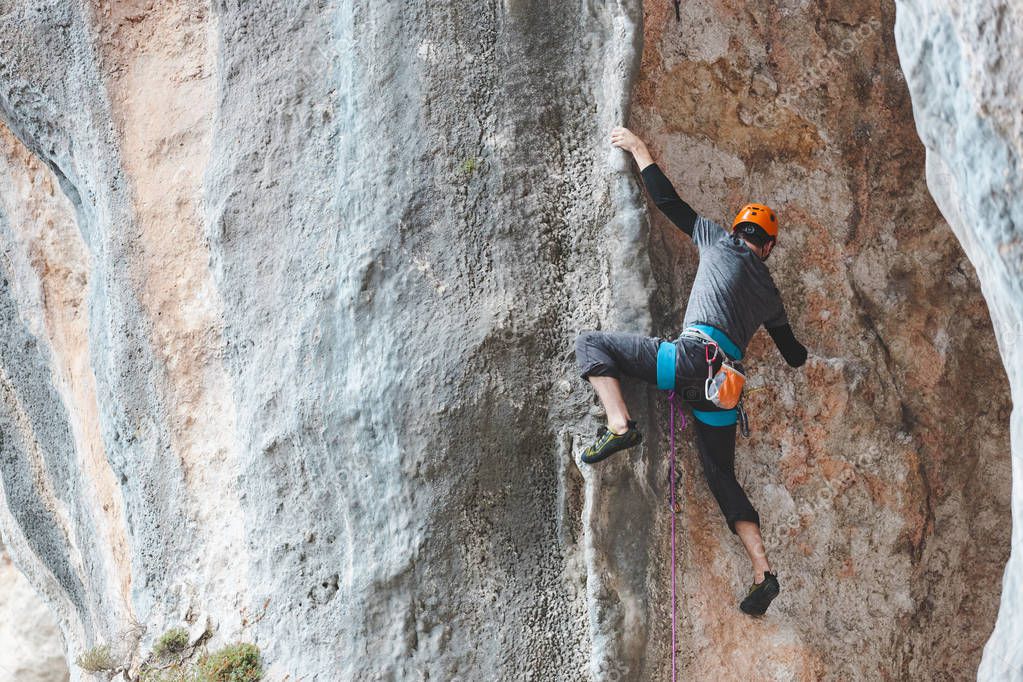 Un hombre con casco sube a la roca. Escalada en la naturaleza. Fitness al aire libre. Estilo de ...
