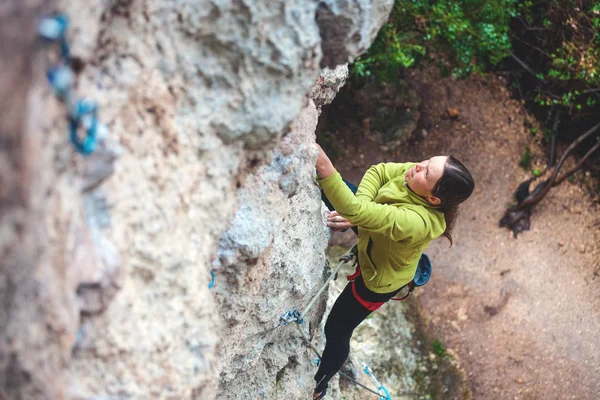 A woman climbs the rock. Climbing in nature. Fitness outdoors. Active ...