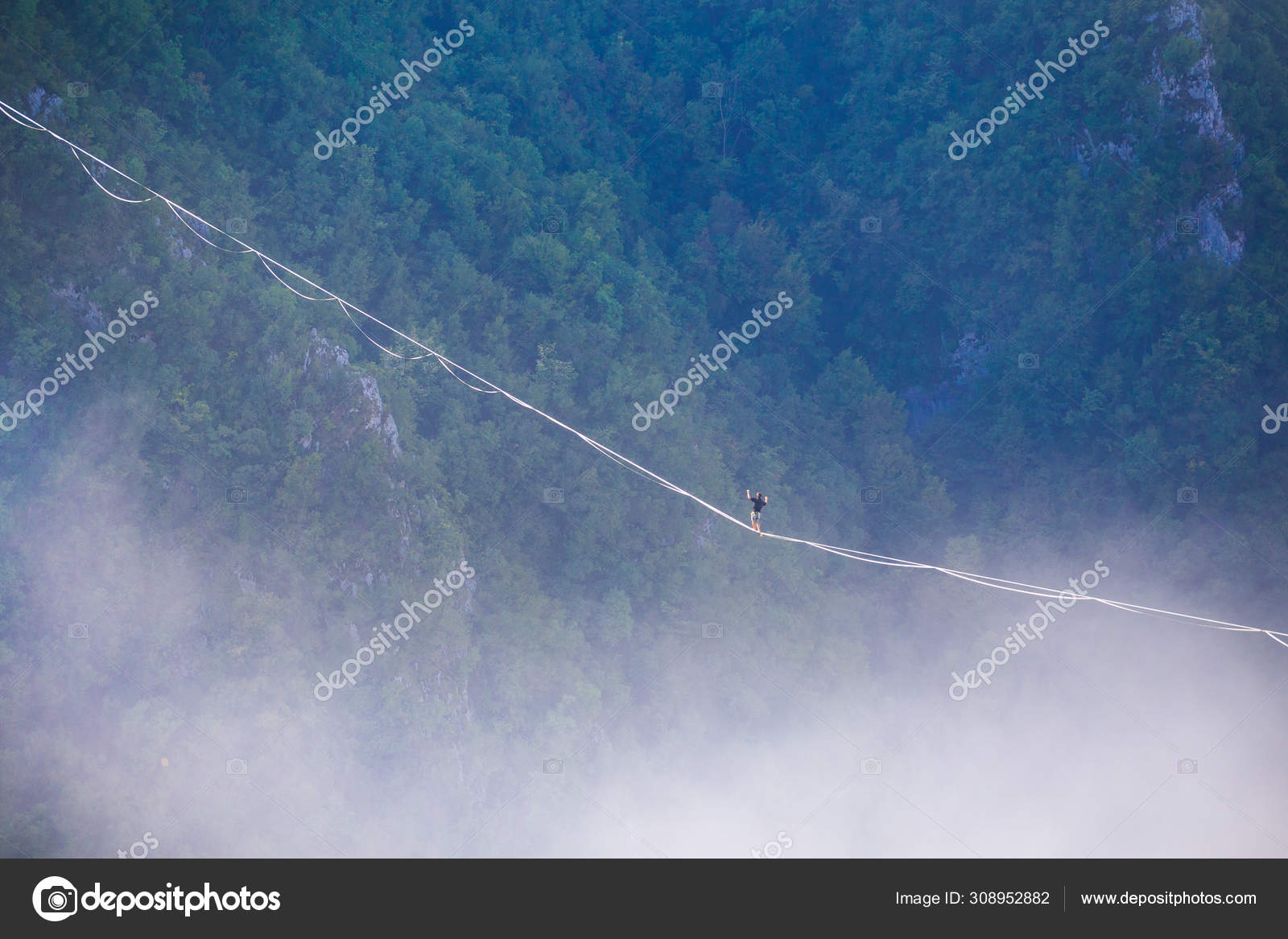 Highliner goes on a sling above the clouds. Stock Photo by ©zhukovvvlad 308952882