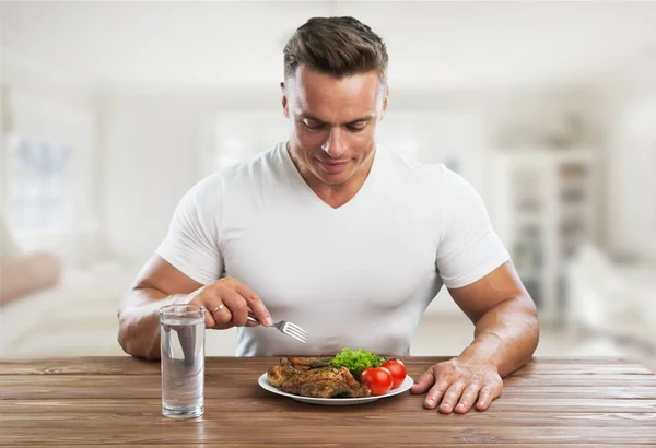 Healthy eating concept, muscular man eating meat and vegetables - Stock ...