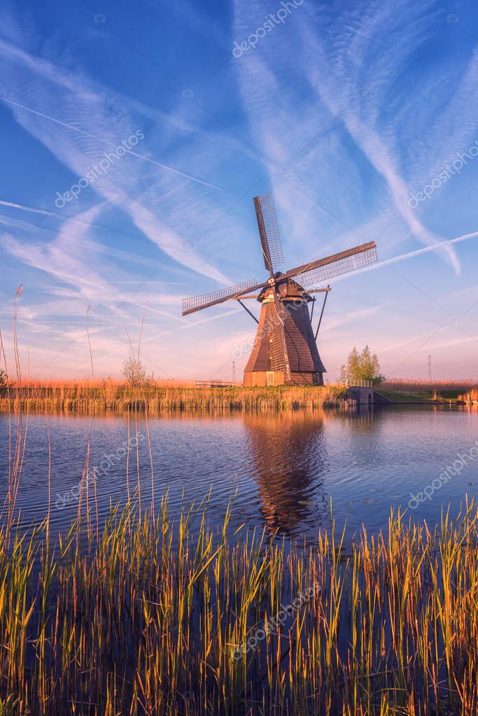 Paisaje panorámico al atardecer con molino de viento, cielo azul y ...