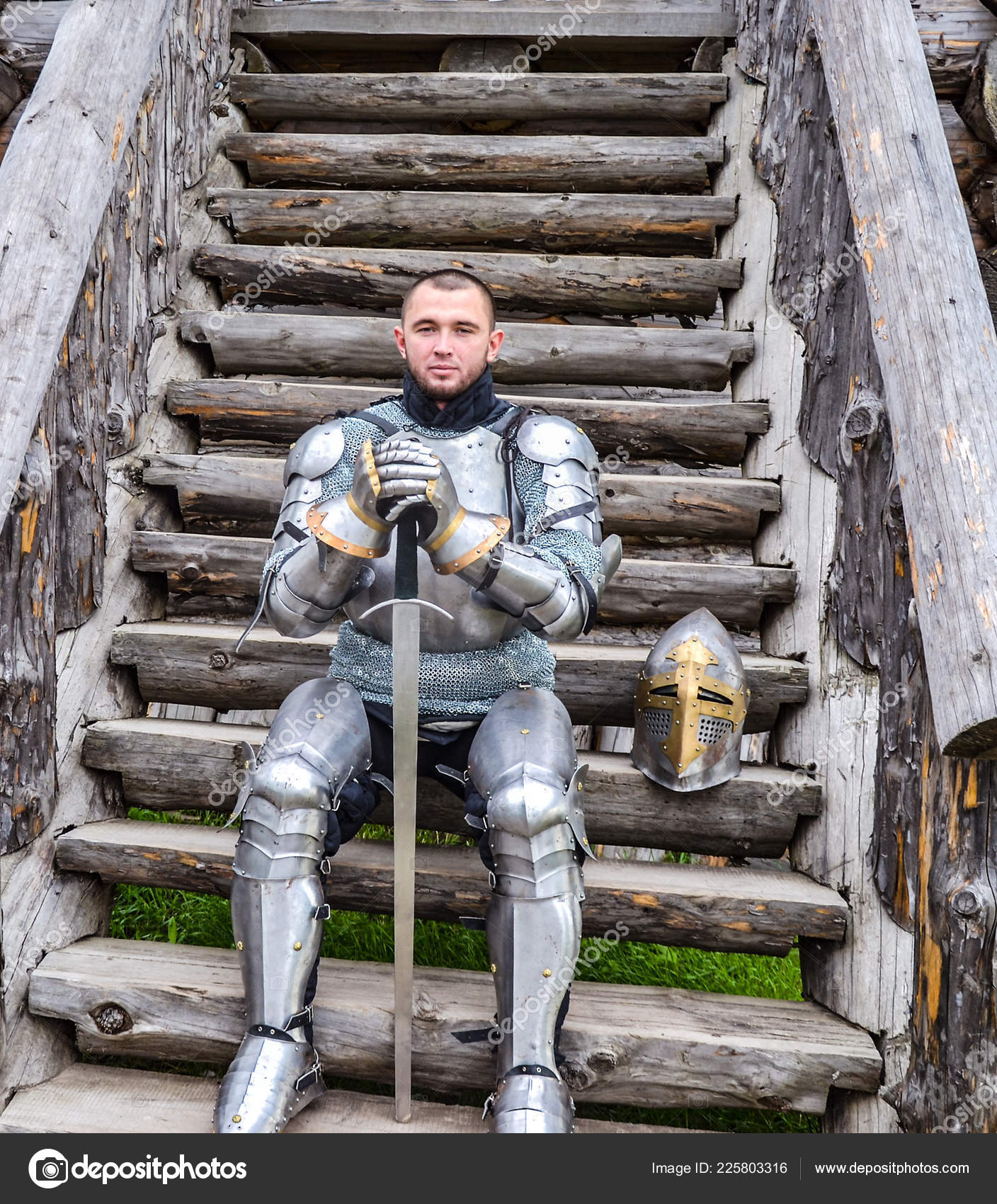 Knight in the armor on the wooden steps. Knightly armor and weapon ...