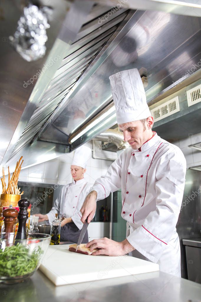 Chef cortando carne en tabla de cortar, cocinero profesional ...