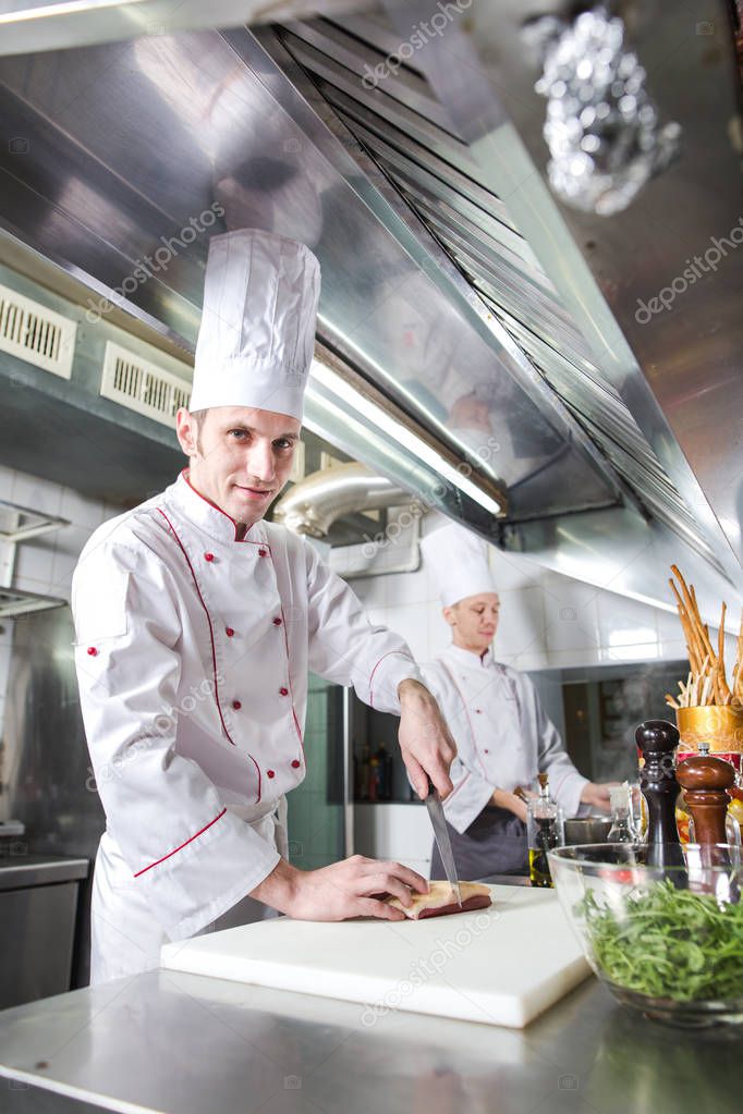 Chef cortando carne en tabla de cortar, cocinero profesional ...