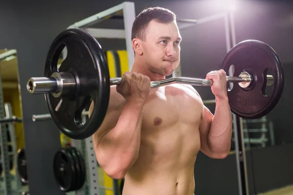 Handsome power athletic man with barbell. Strong bodybuilder with six ...