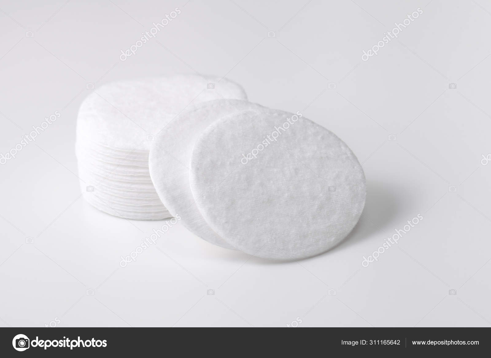 A stack of cotton pads and a number of separate discs deployed on the ...