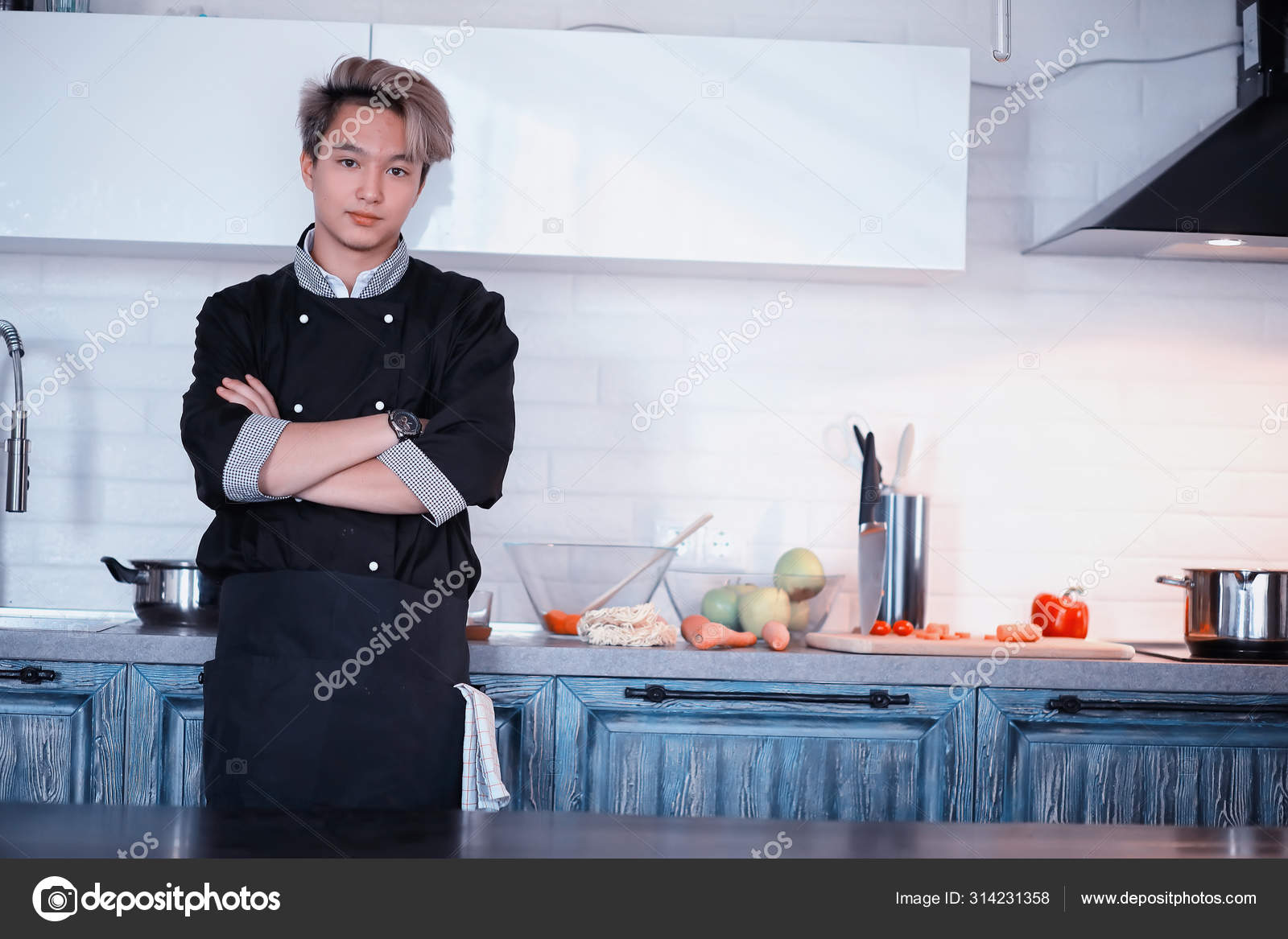 Asian cook in the kitchen prepares food in a cook suit — Stock Photo ...