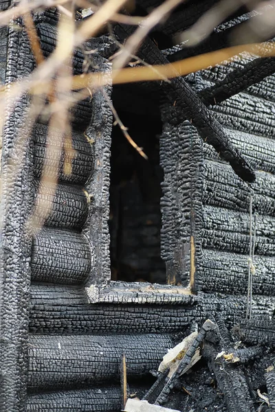 Wooden house after the fire. Coals on the logs. The ashes of the house ...