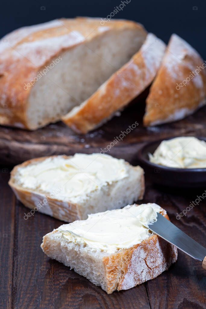 Dos trozos de pan Classic Boule fresco con mantequilla en una mesa de ...