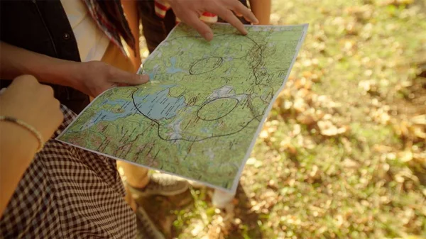 Friends learning the map on their route on hike in the national park ...