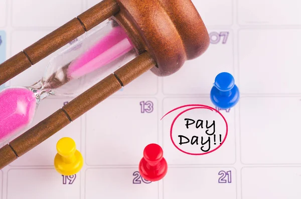Payroll or accounting concept,hourglass, thumbtack and word PAY DAY for ...