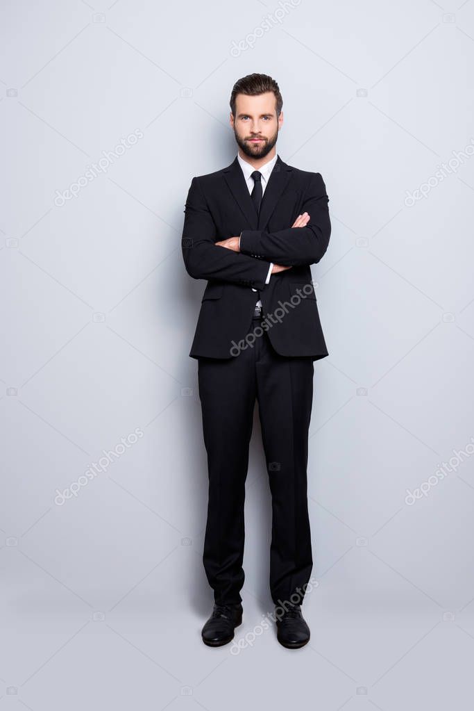 Retrato de cuerpo completo de hombre de negocios viril y duro en traje negro con corbata con los ...
