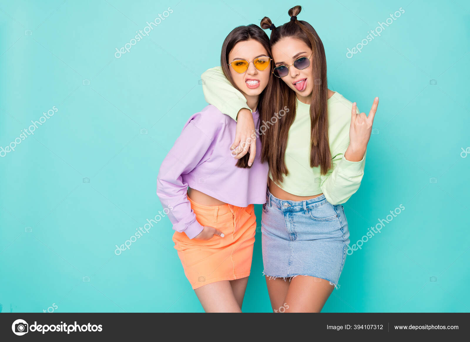 Photo of two behavior harsh ladies show horns hands stick tongue out ...